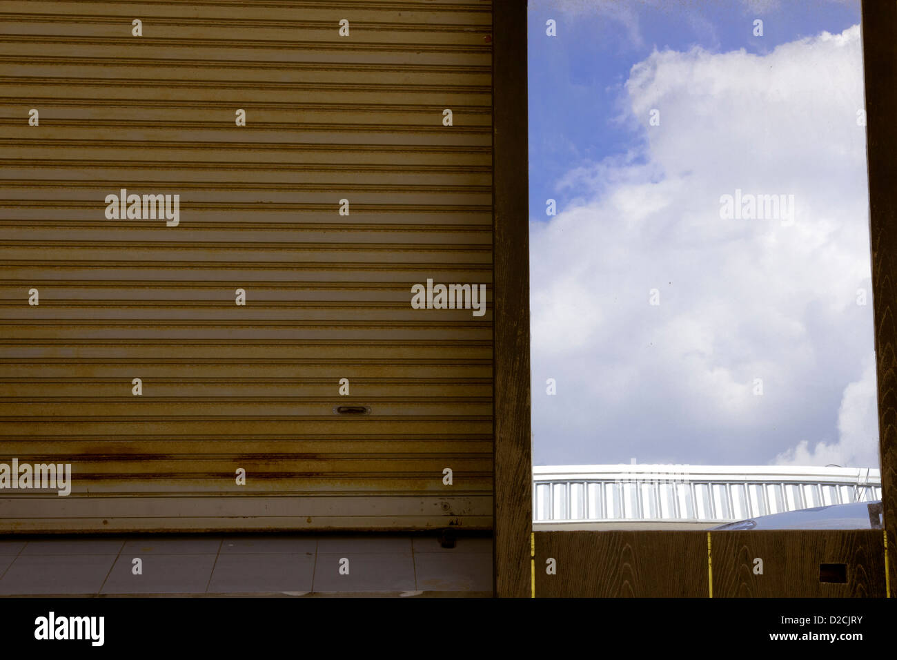 Standing mirror propped up in front of closed storefront with rolled up ...
