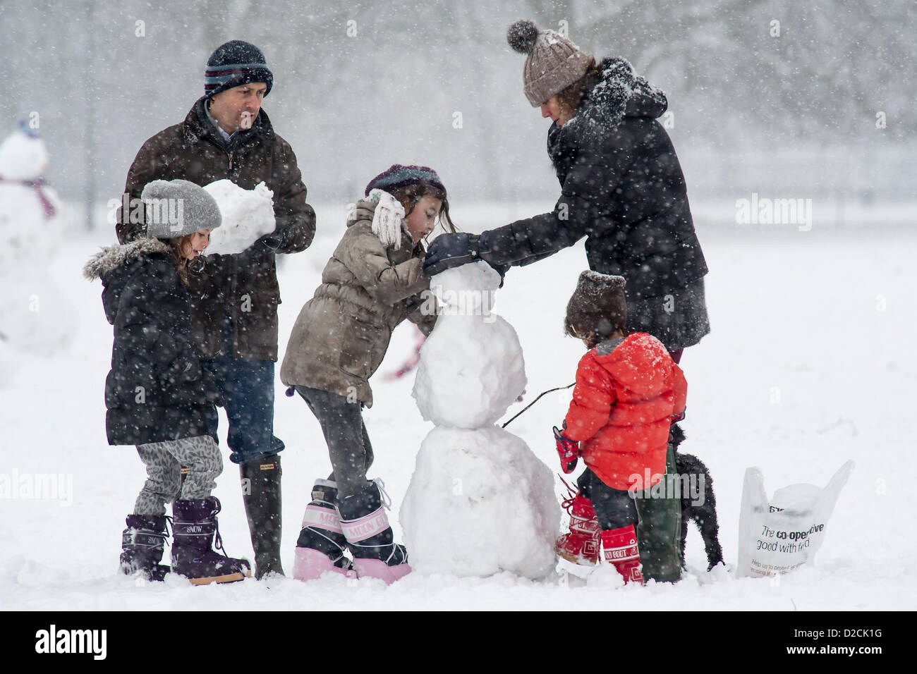 Families build snowmen. The snow falls in the Clapham Common area and ...