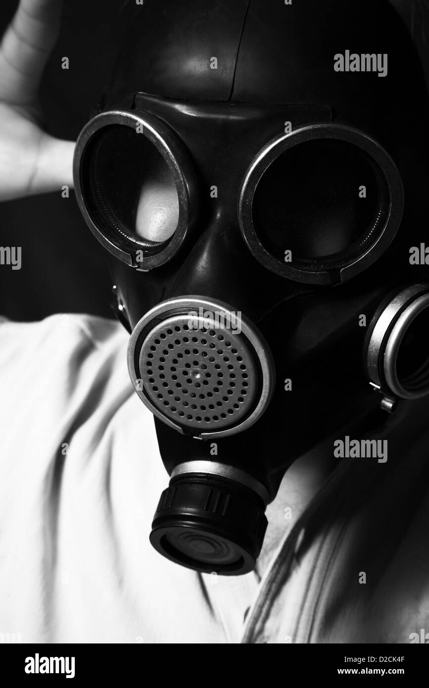 The person in a gas mask holds hands a head Stock Photo - Alamy