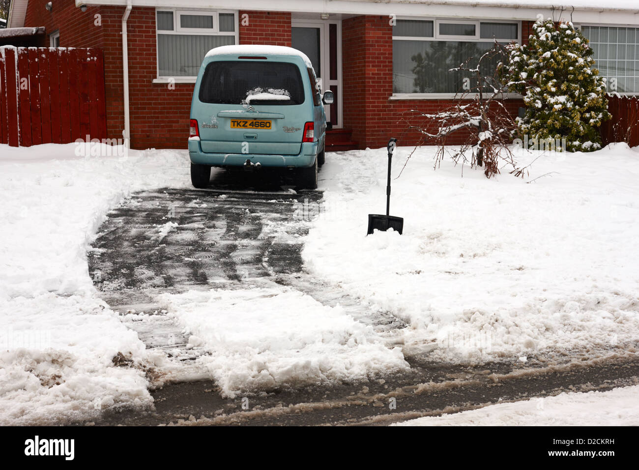clearing driveway of snow in front garden of a house newtownabbey uk ...