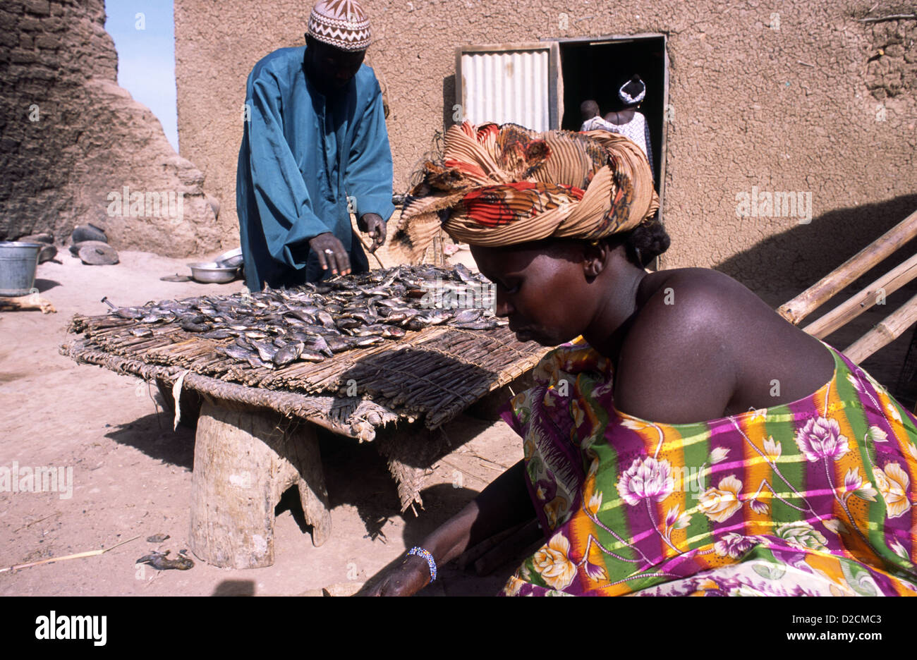 In Mali, Africa, a fisherman and his wife dry locally caught fish ready ...