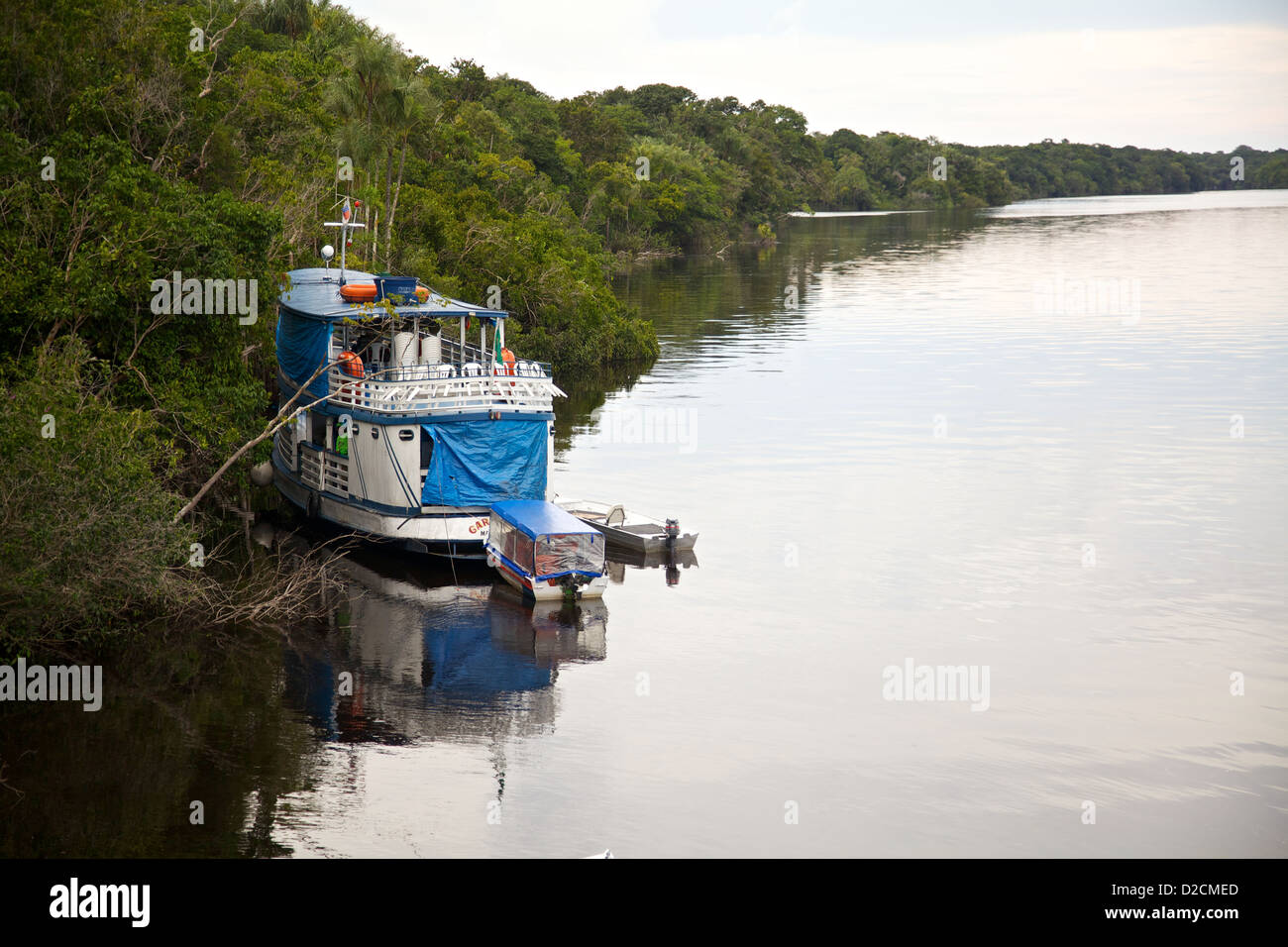 Amazon River boat docked along lush rainforest banks, showcasing eco ...