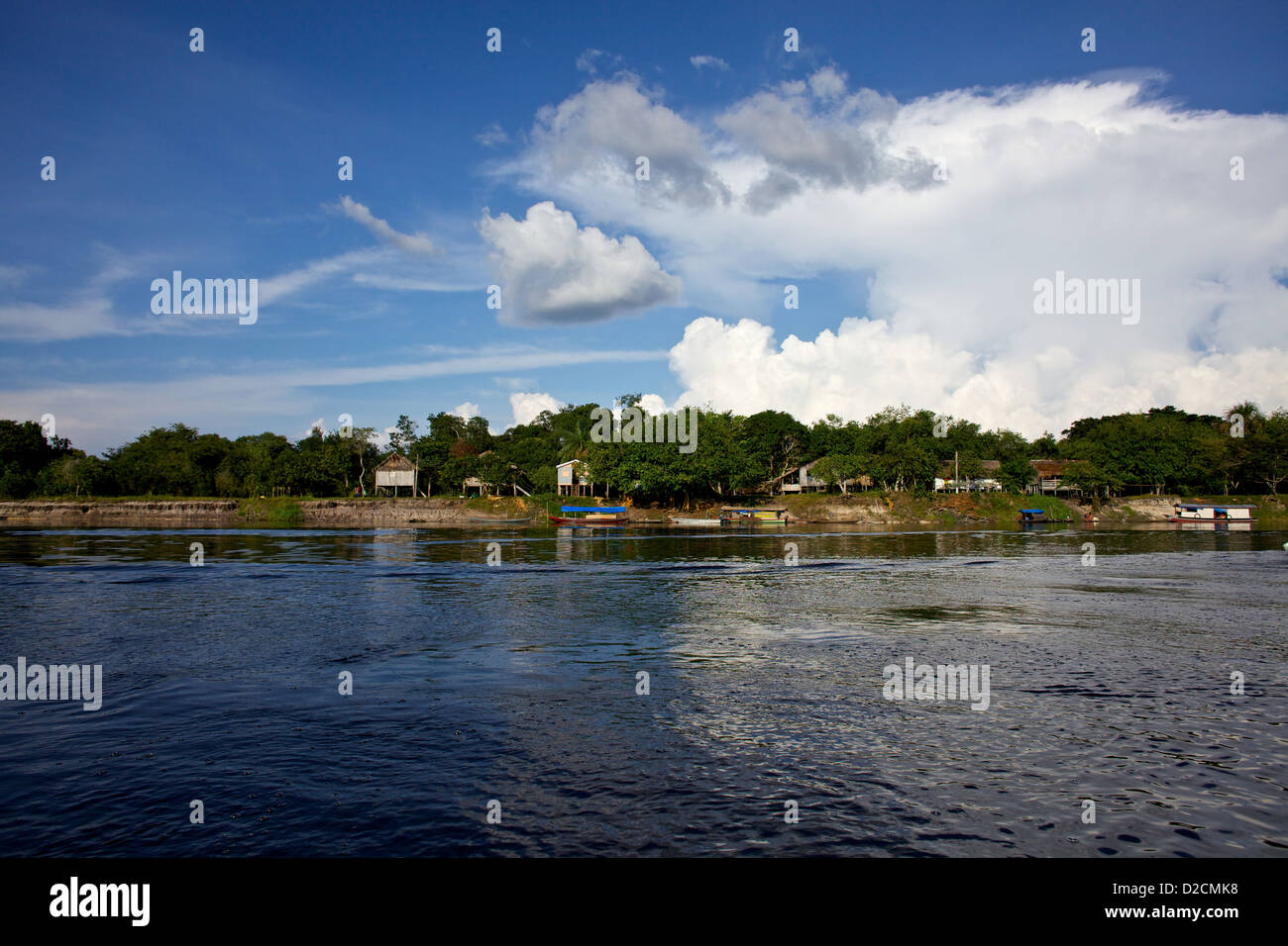 Scenic Amazon River village with stilt houses, lush greenery, and calm ...