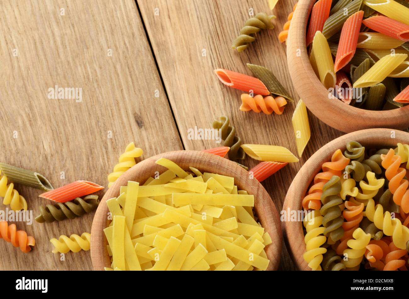 Raw tricolor pasta set on the wooden table with copy-space Stock Photo ...