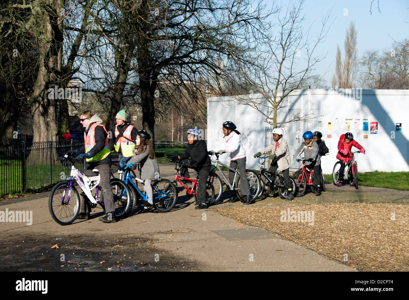Children bicycle safety training, lined up in a row with adult ...