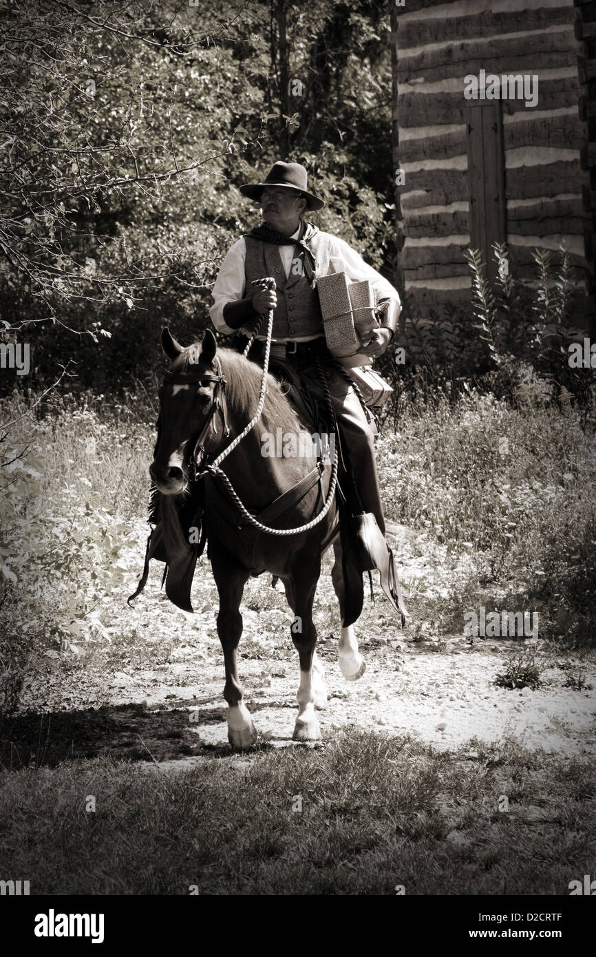 A cowboy delivering a Christmas present during the Holidays. Log cabin ...