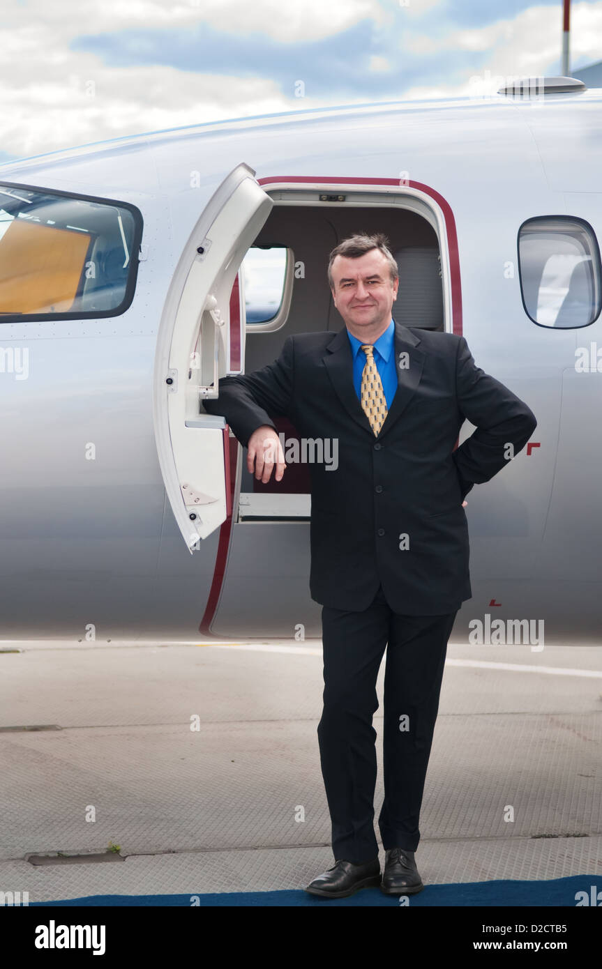 Smiling Businessman at Corporate Jet Stock Photo - Alamy