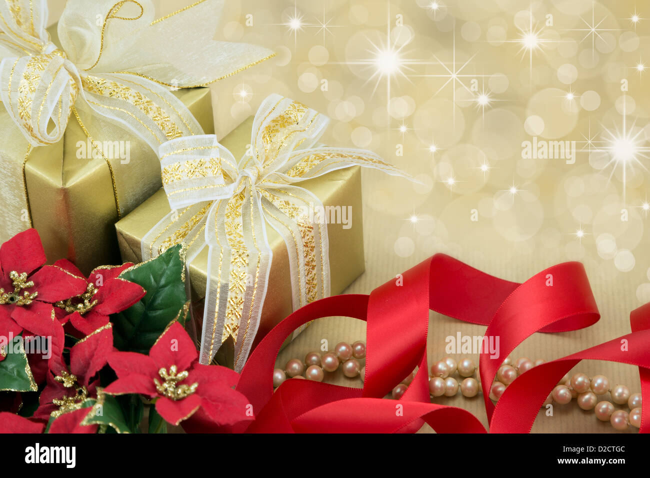 Two gold wrapped presents with red ribbon, flowers and a gold sparkle ...