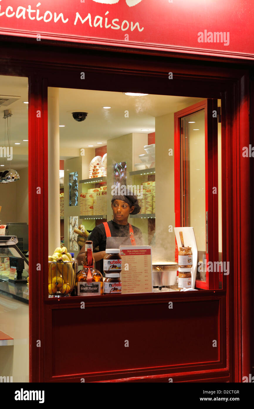black saleswoman at the stand of a street sale in a cream shop in ...