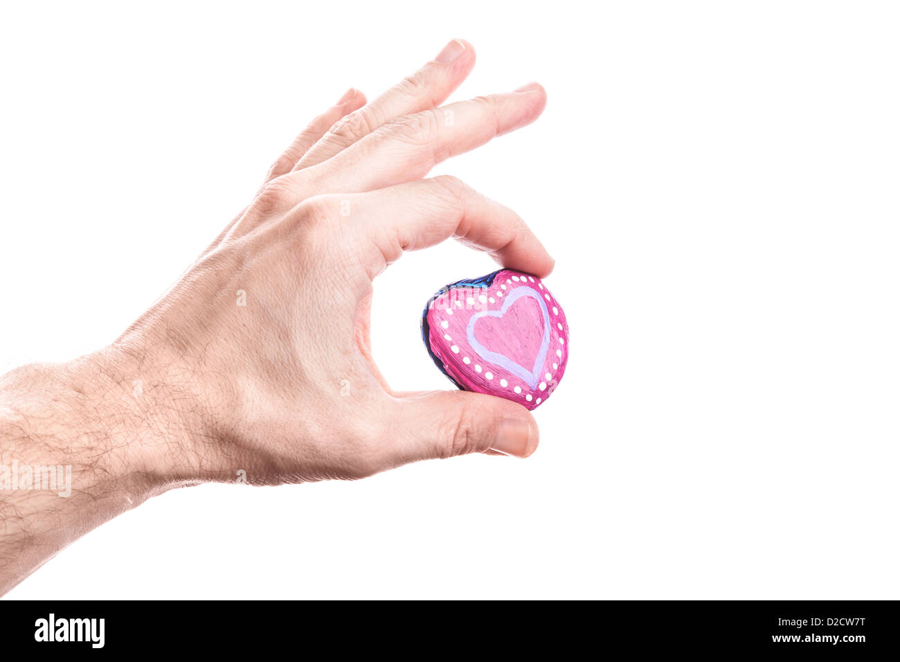 Handmade pink painted heart shaped stone in man's hand isolated on ...
