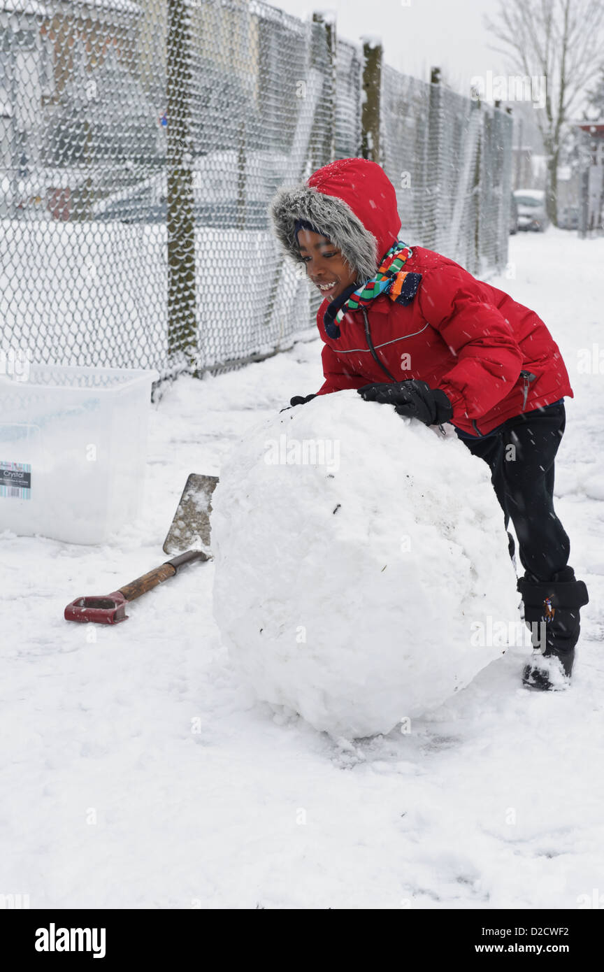 Young boy rolling snowball, United Kingdom Stock Photo - Alamy