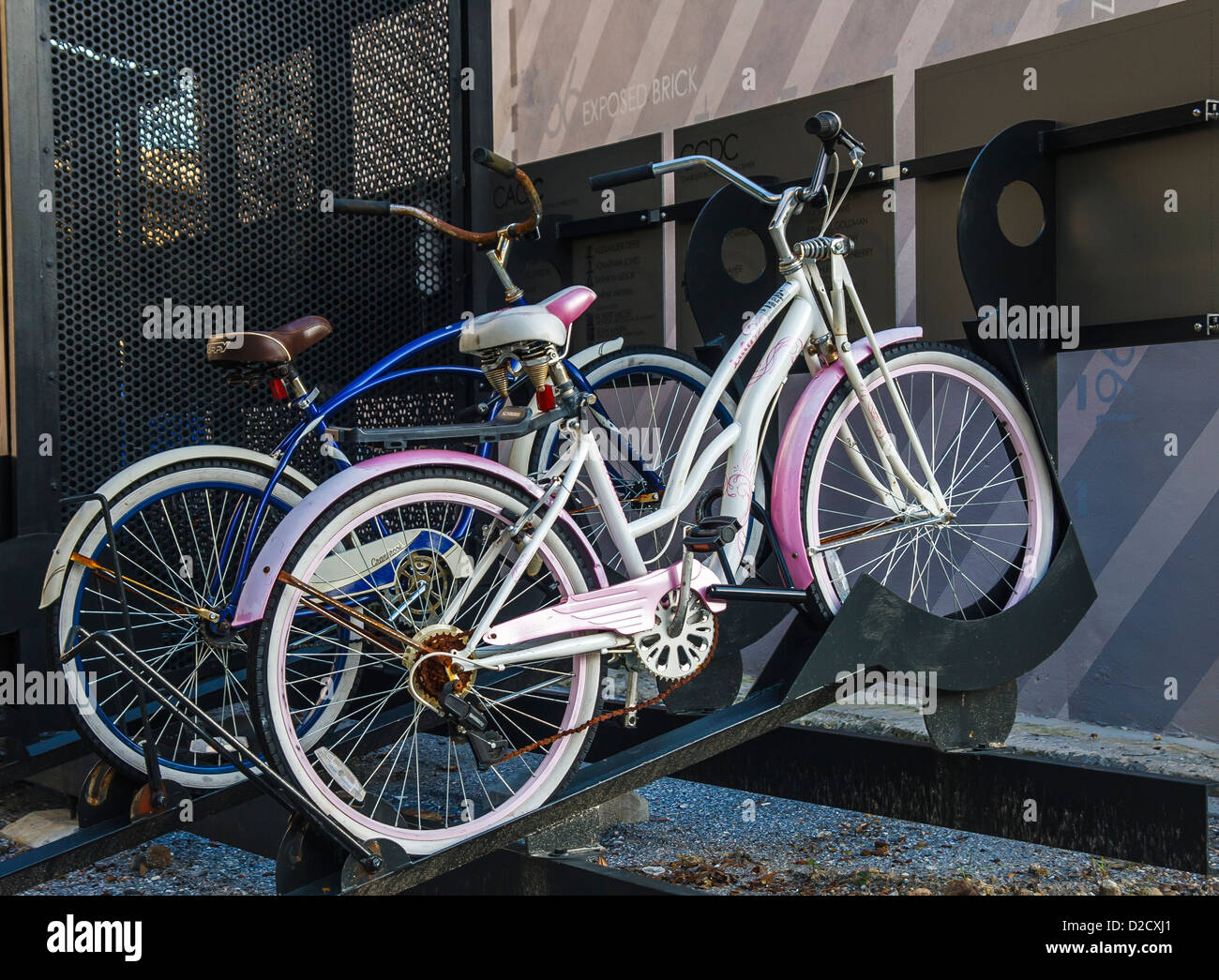 Two old bicycles on a rack connected to a wall Stock Photo - Alamy