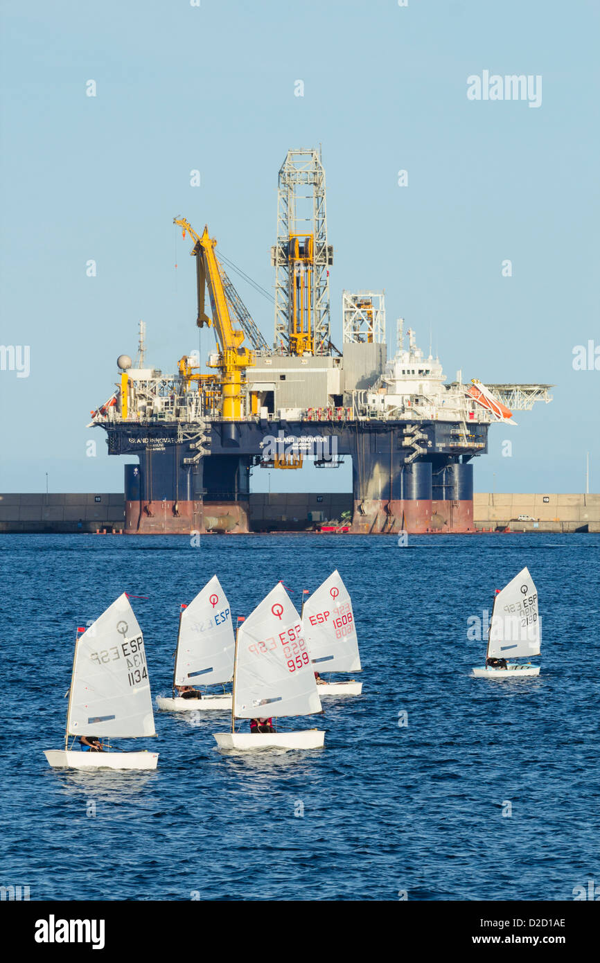 Optimist dinghies sailing in front of Island Innovator semi submersible ...