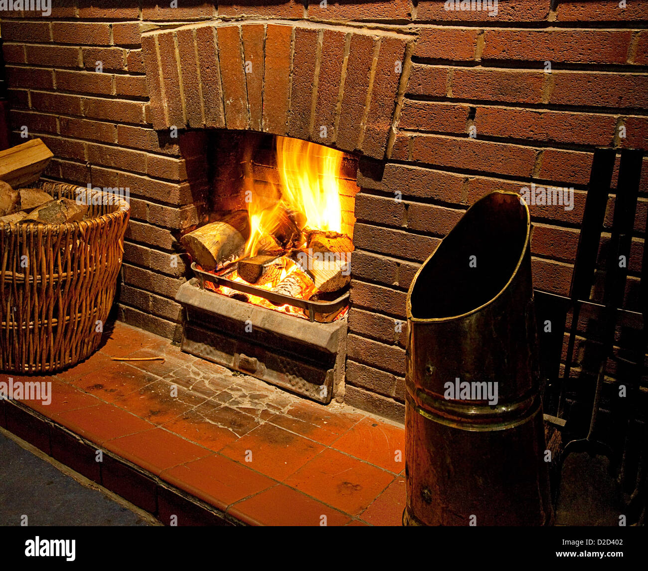 Cosy bright Roaring log fire with brick surround glowing with flames ...