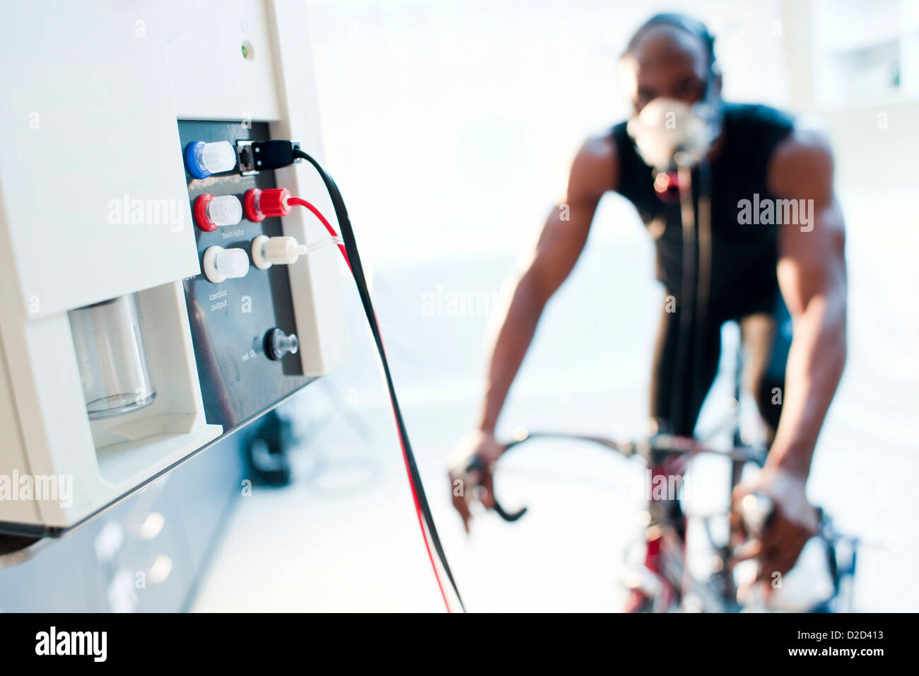 MODEL RELEASED Performance testing Athlete riding an exercise bike ...