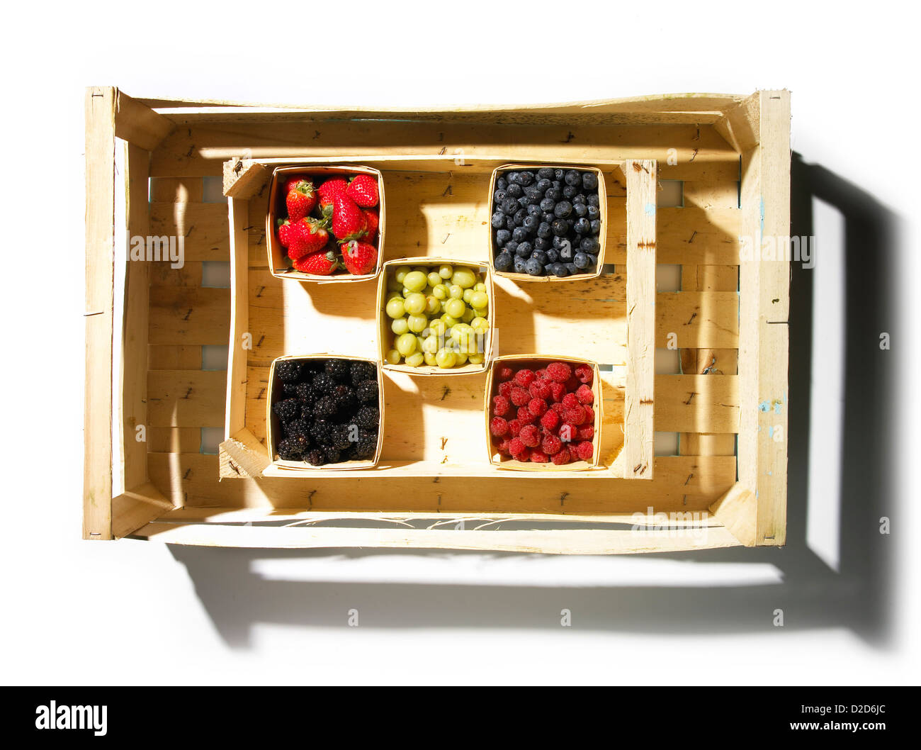 Overhead view of crate with various fruit cut out white background ...