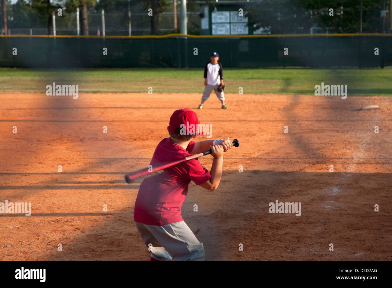 Rear view of a boy preparing to swing a bat on baseball diamond Stock ...
