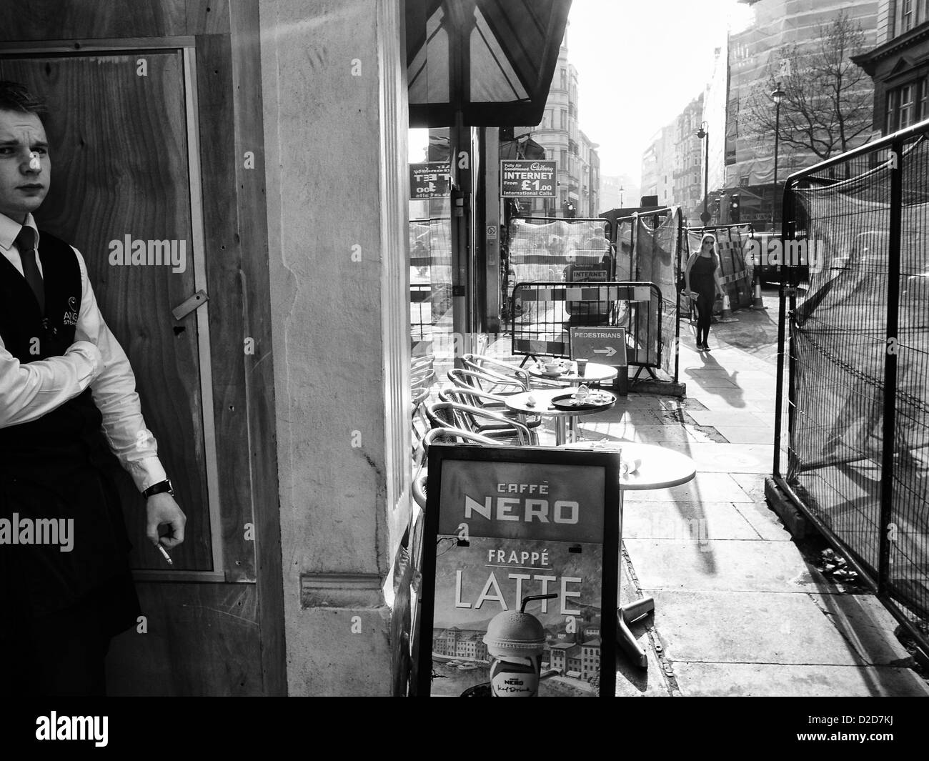 young waiter smooking in front of his restaurant Stock Photo - Alamy