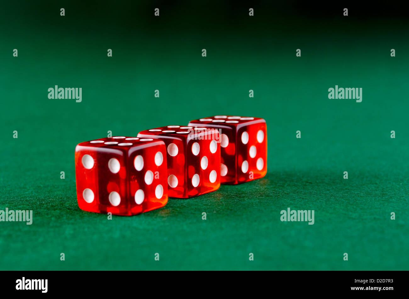 Three red dice on a green background Stock Photo - Alamy