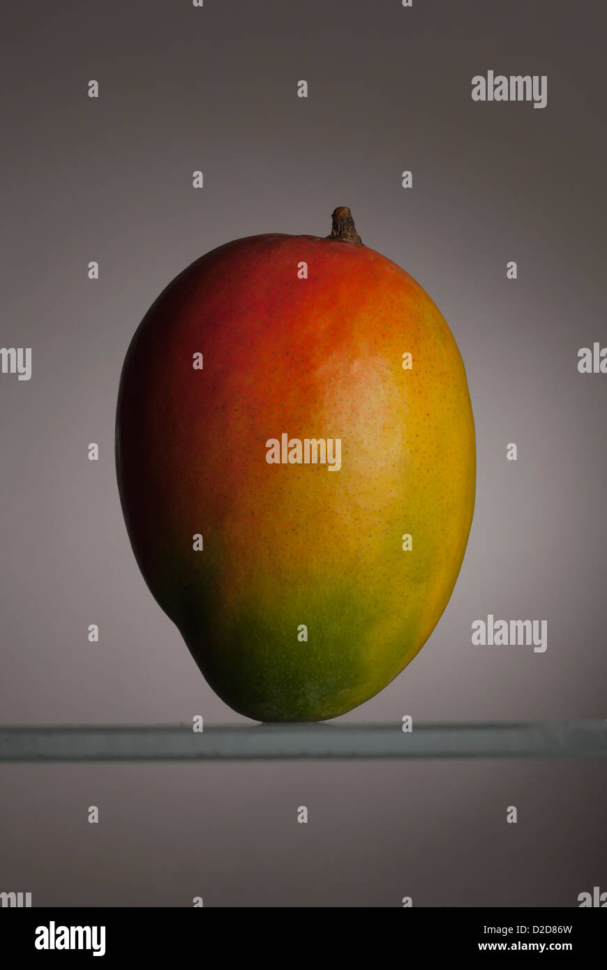 A mango standing up on a glass shelf Stock Photo - Alamy