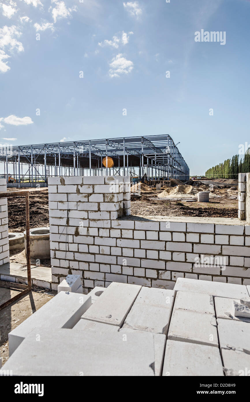 Incomplete brick wall with construction frame in background of ...