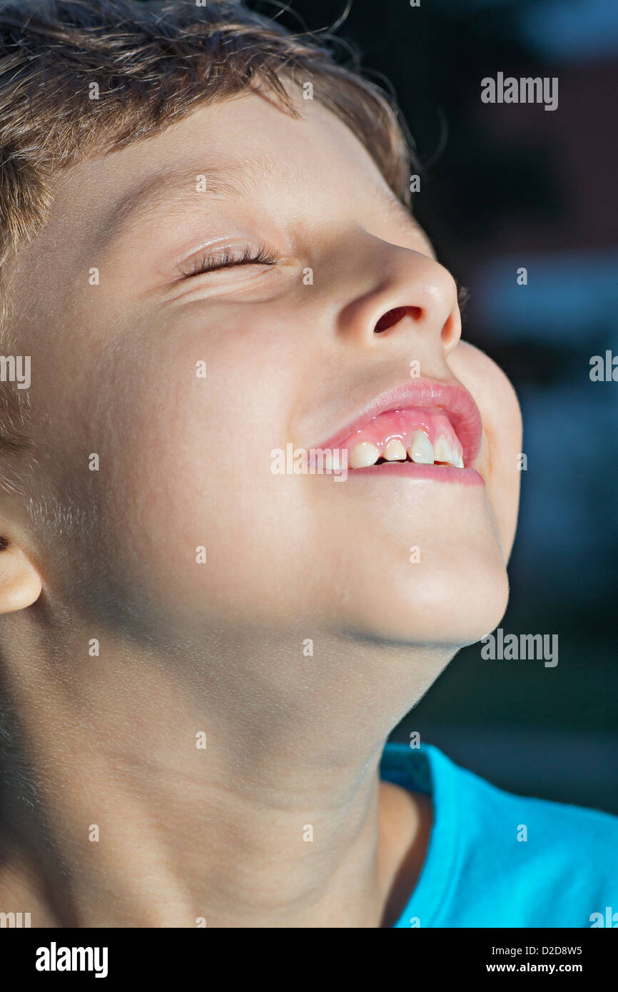 A boy with his eyes closed and a joyous expression Stock Photo - Alamy
