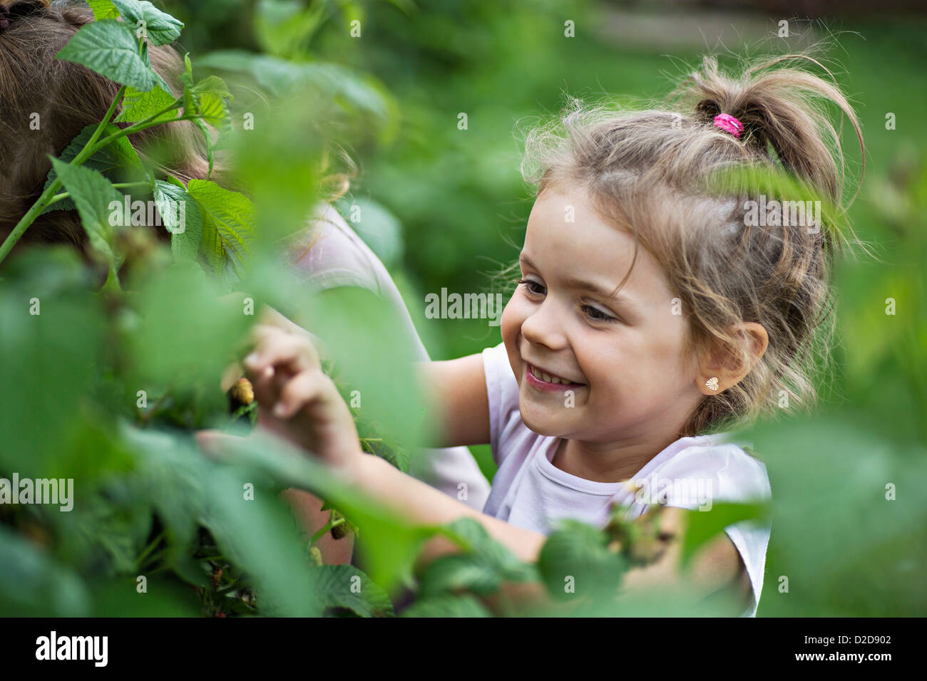 A young grinning young girl standing next to a friend Stock Photo - Alamy