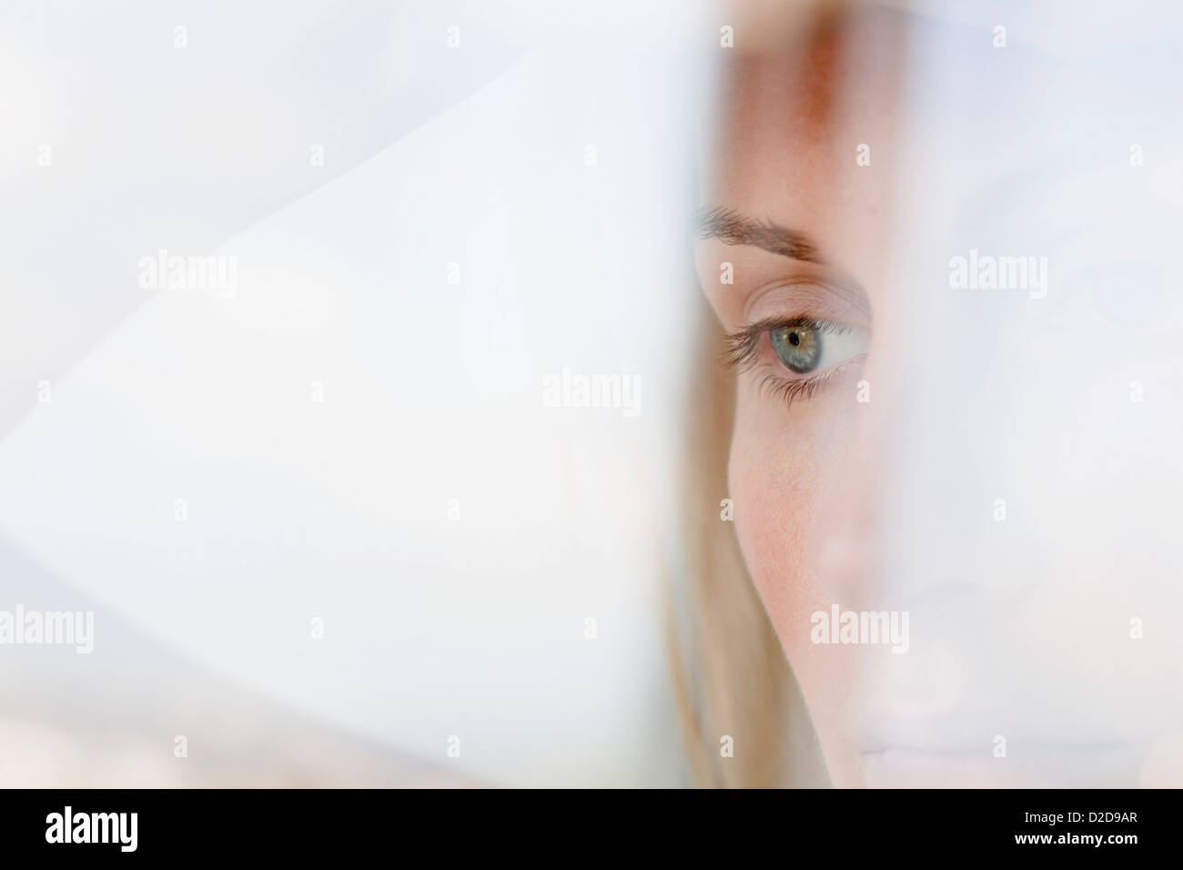 A serious woman looking contemplatively out a window Stock Photo - Alamy