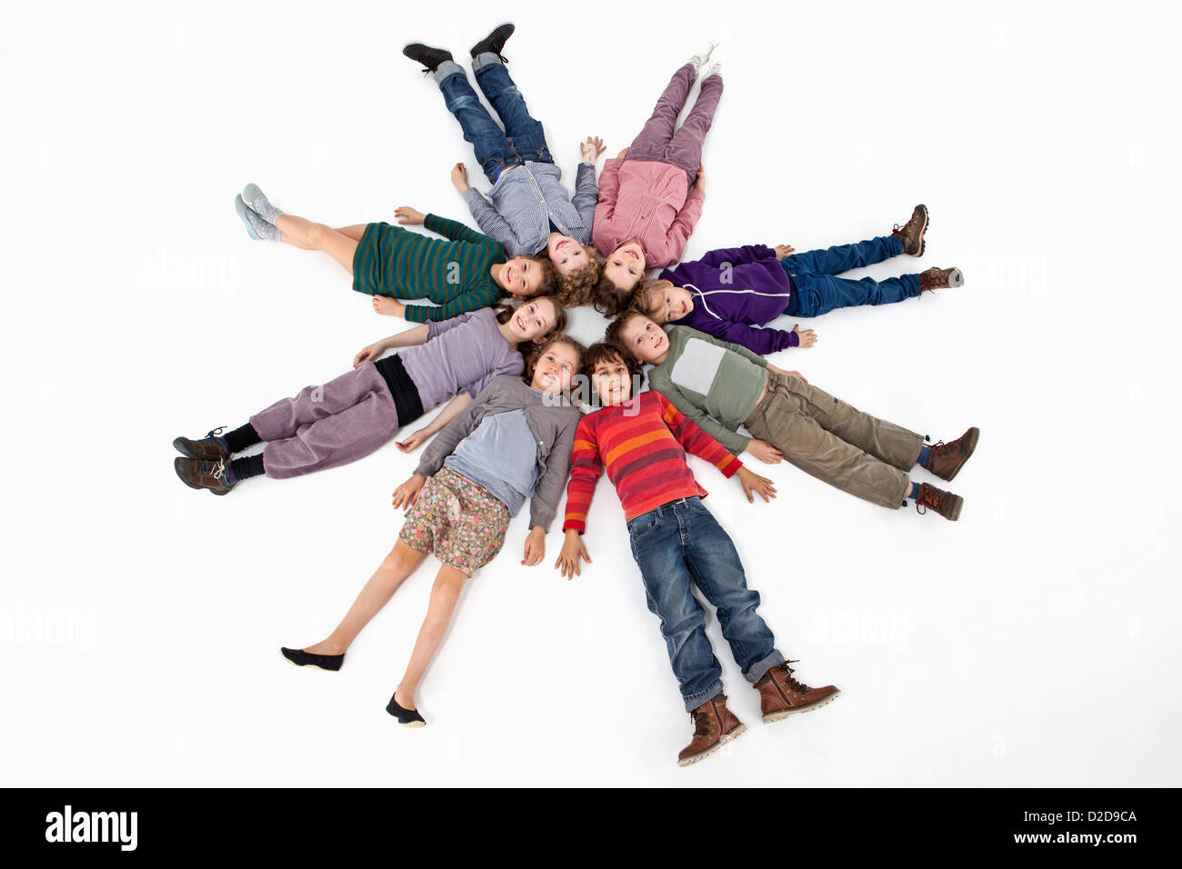 A group of kids lying on their backs in a circle Stock Photo - Alamy