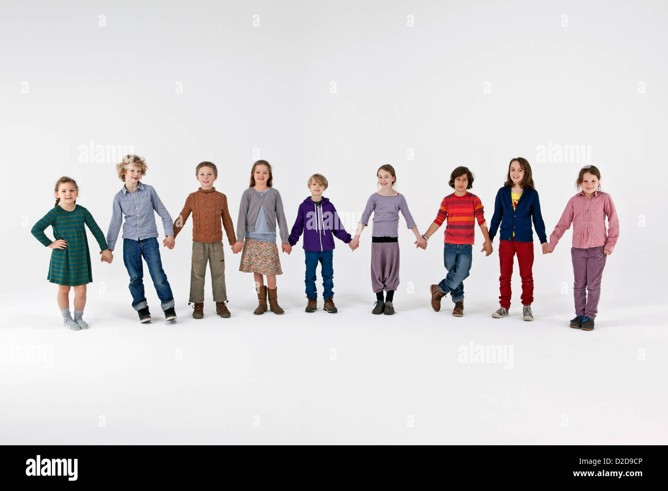 A group of kids standing in a row and holding hands Stock Photo - Alamy