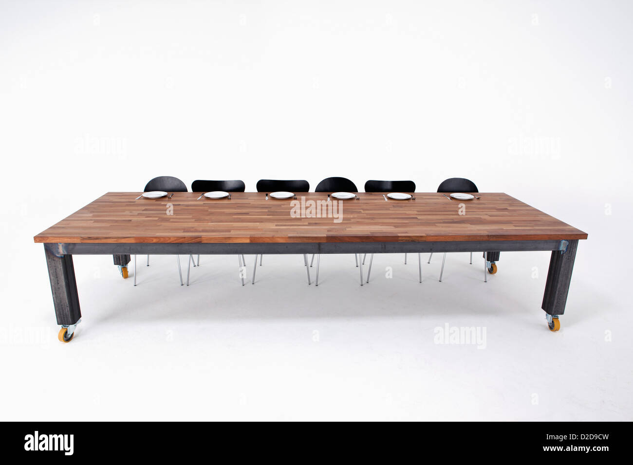 A large wood table with six chairs and six empty place settings Stock ...