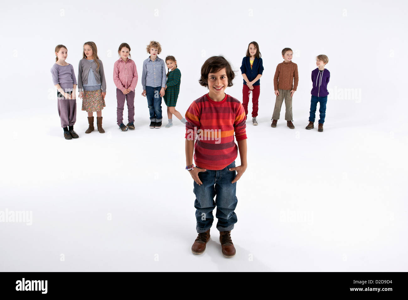 A boy standing in front of a line of kids Stock Photo - Alamy