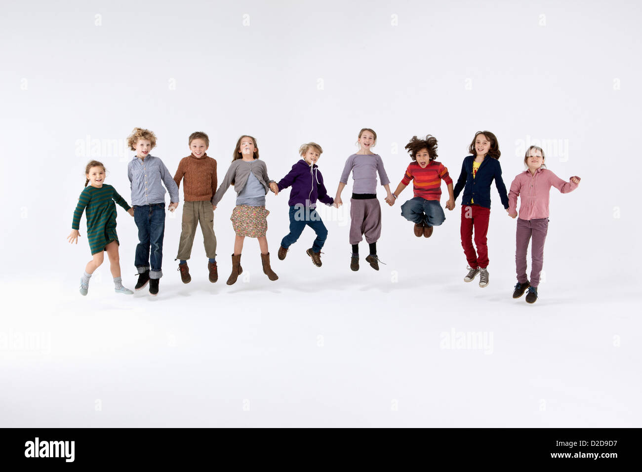 Nine kids jumping while holding hands and in a row Stock Photo - Alamy