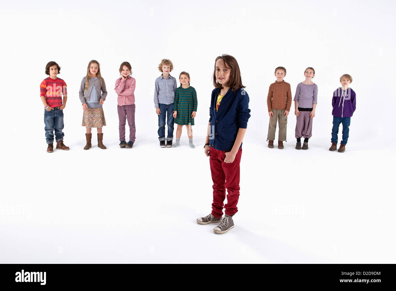 A boy standing in front of a line of kids Stock Photo - Alamy
