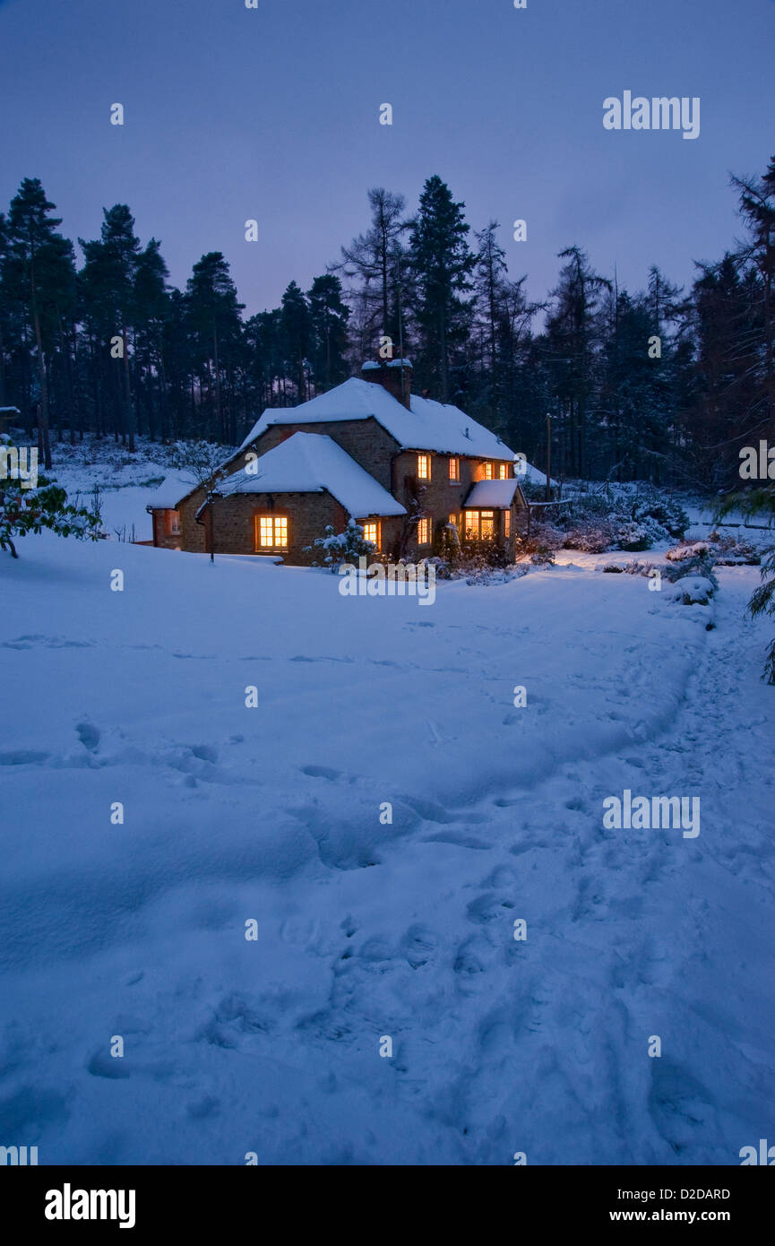 Christmas card image of a snowy cottage at night with all the lights on ...