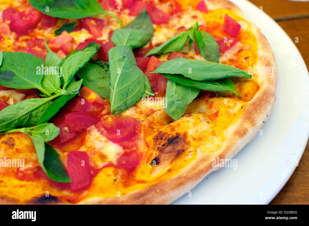Typical, flat Italian Pizza with fresh Basil Stock Photo - Alamy