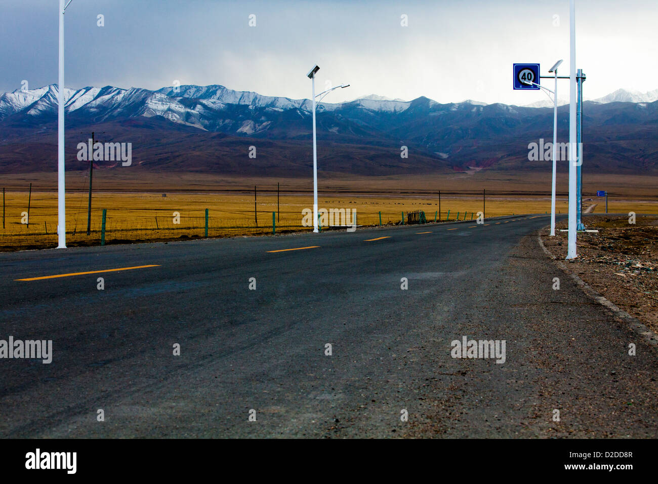 Road going through field into Qilian Mountain in Qinghai province ...