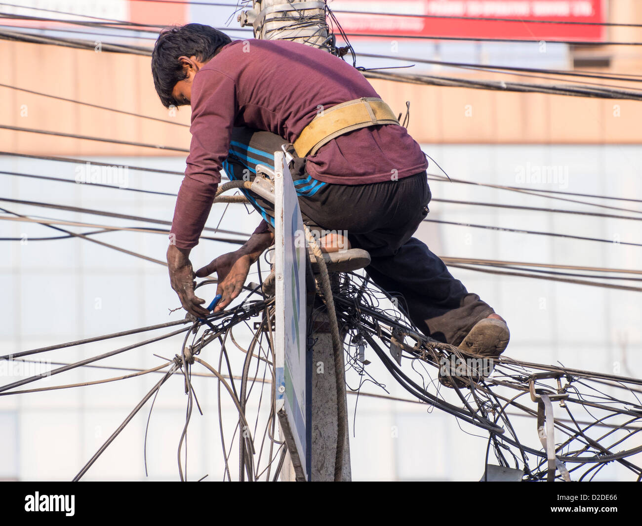 An electrician works on a tangle of electric wires in Kathmandu, Nepal ...