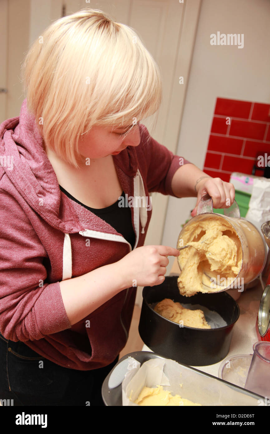 Teenage girl baking a cake Stock Photo - Alamy