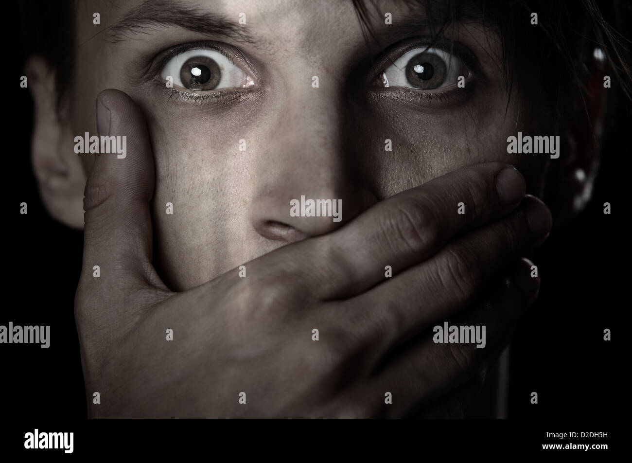 Afraid man covering his mouth by the hand Stock Photo - Alamy