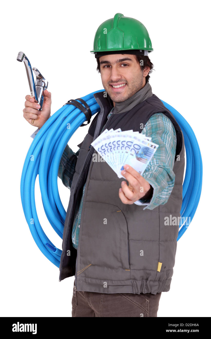 Plumber holding wedge of cash Stock Photo - Alamy