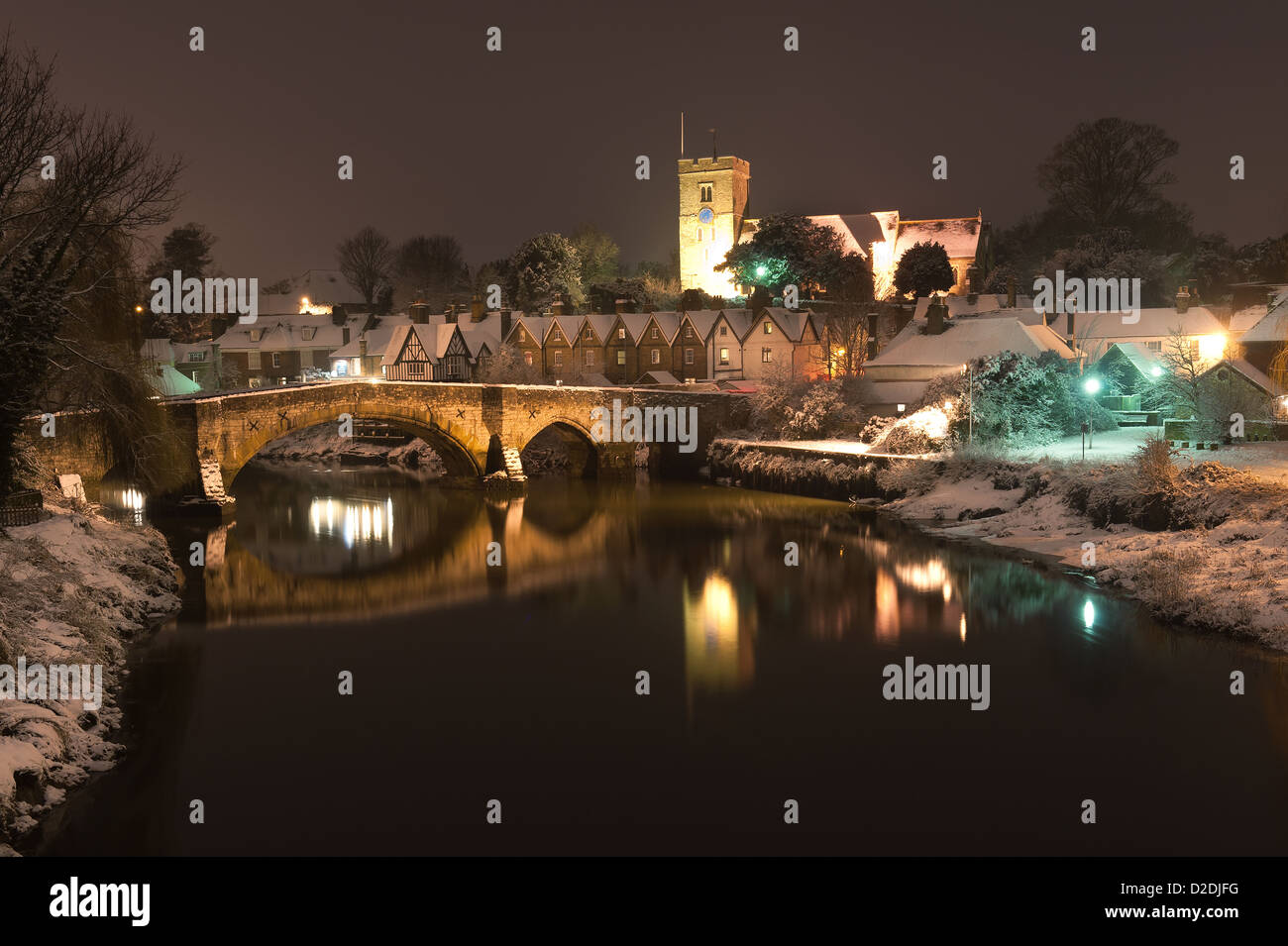 Snow bound village Aylesford with a Medieval bridge over calm tidal ...
