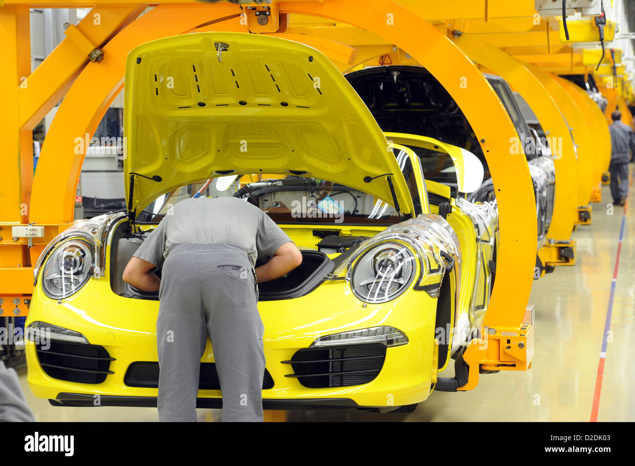 An employee of Porsche AG work at the assembly line of the model ...