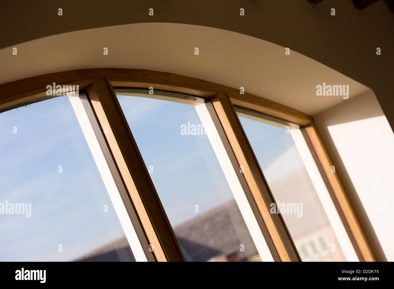 Tall arched double glazed window in a newly converted barn in the rural ...