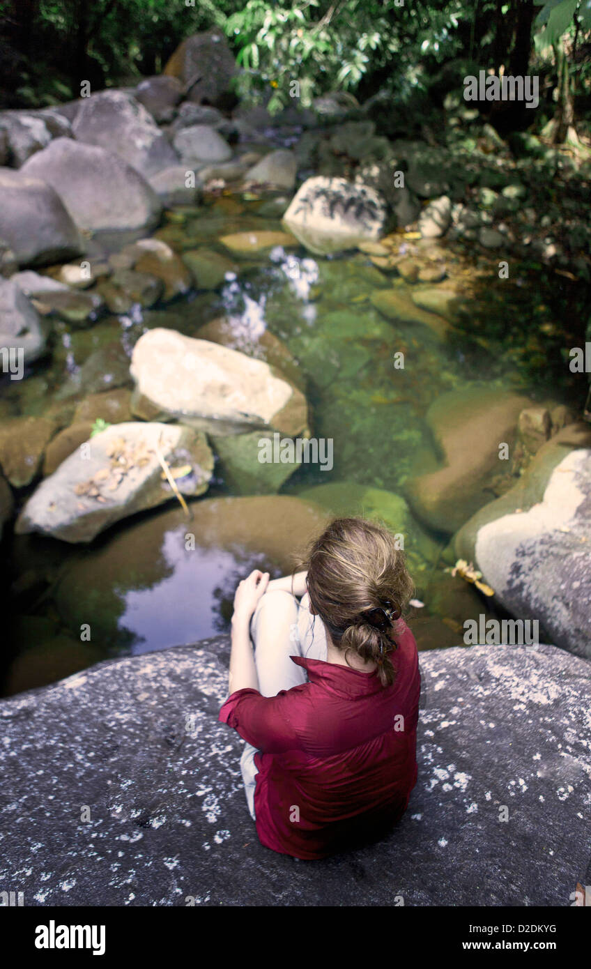 Malaysia, Borneo, Gunung Gading park, young woman sitting on the edge ...