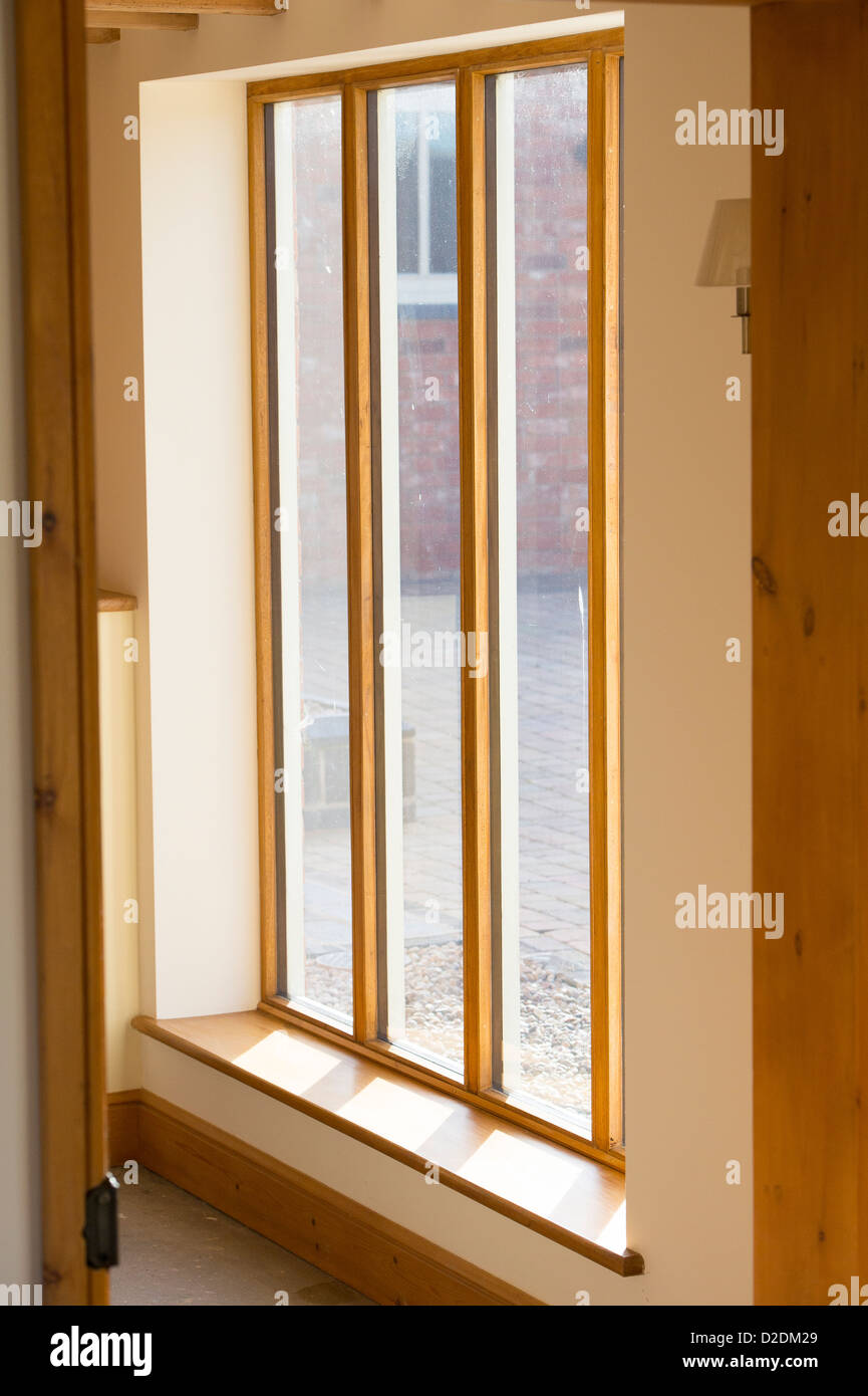 Tall window with wood surround in a newly converted barn in the rural ...
