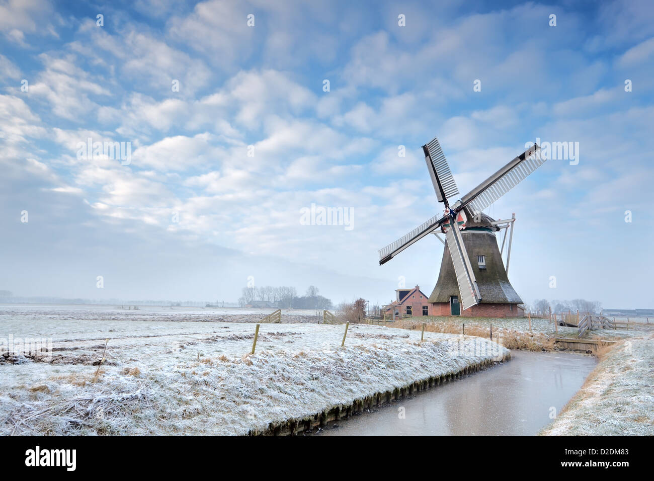 Dutch windmill by canal in winter Stock Photo - Alamy