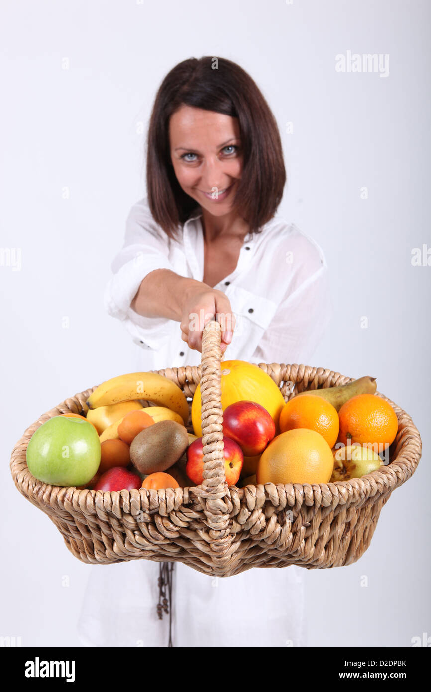 Woman holding basket of fruit Stock Photo - Alamy