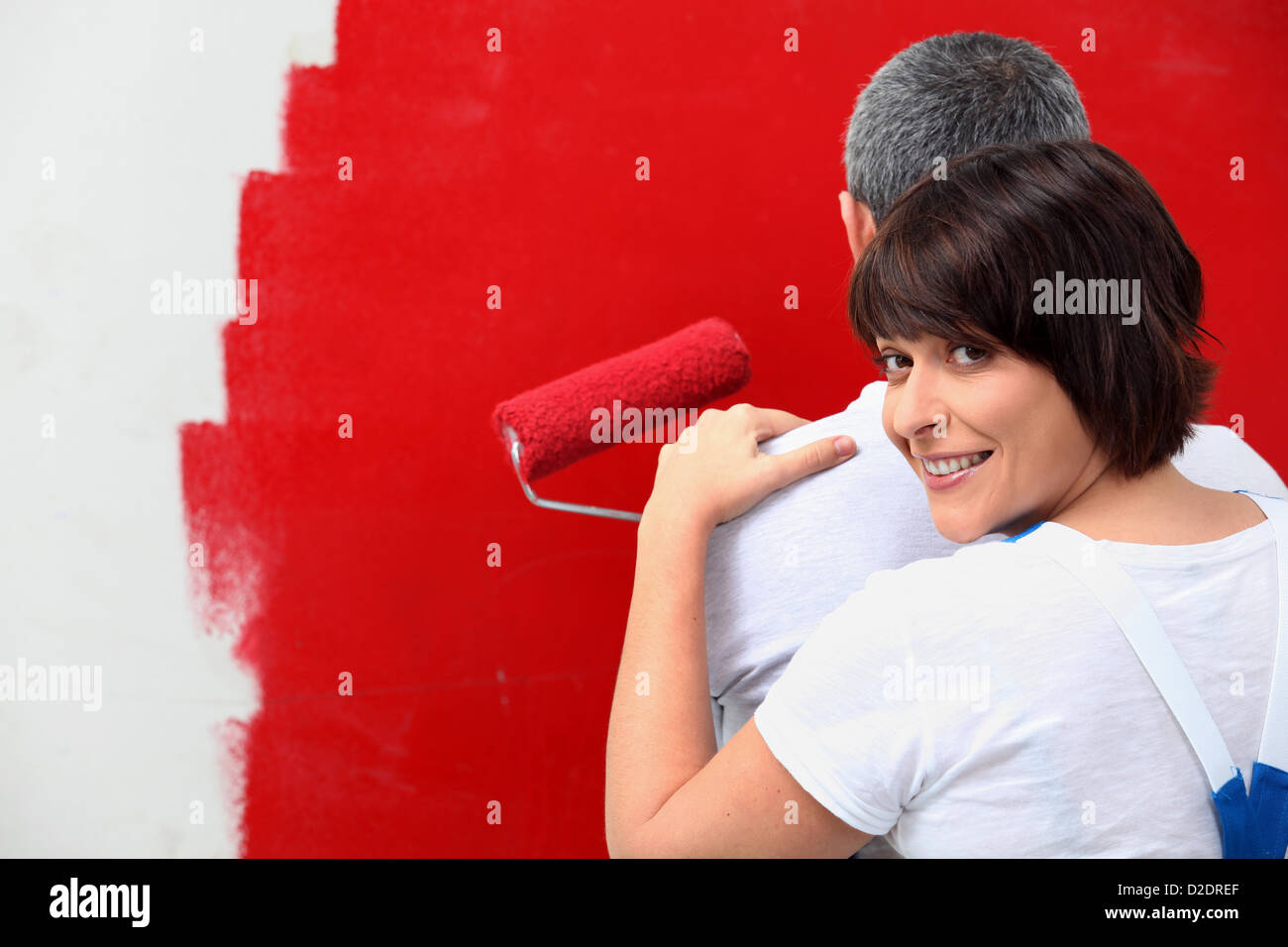 Couple painting a wall red Stock Photo - Alamy