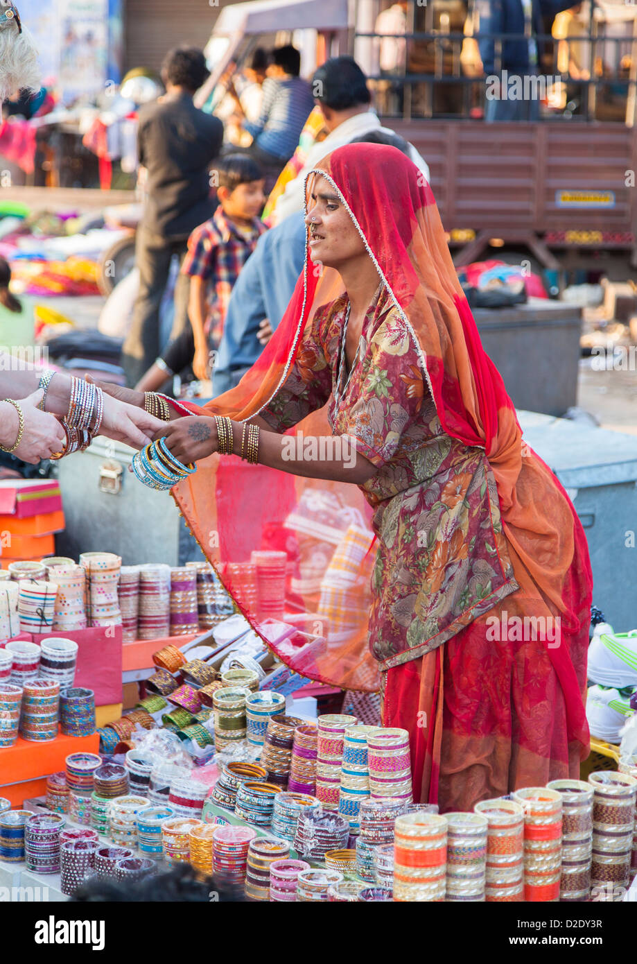 Indian lady in typical red traditional sari dress selling bangles at ...